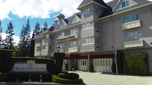 Um hotel grande, de vários andares, com uma placa em destaque que diz 'Woodcrest Hotel'.
