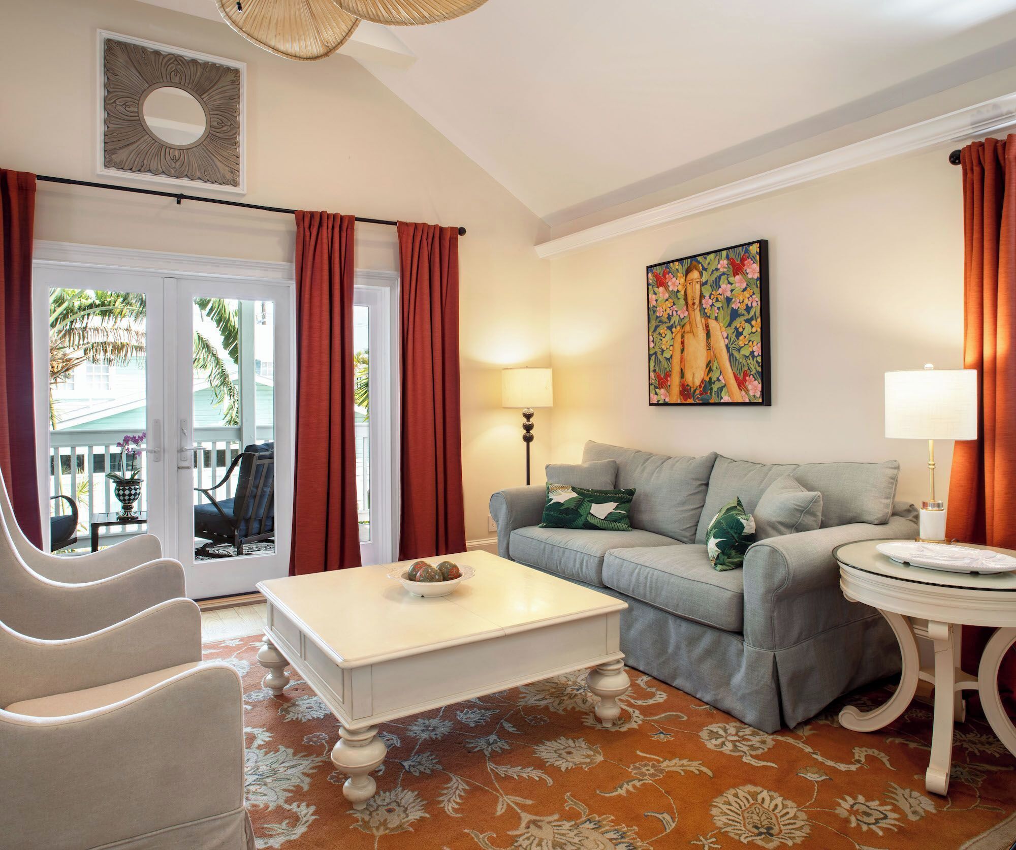 Uma sala de estar com um sofá, duas poltronas, uma mesa de centro e um quadro na parede.