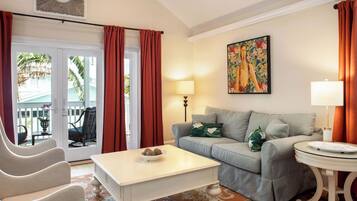 Uma sala de estar com um sofá, duas poltronas, uma mesa de centro e um quadro na parede.