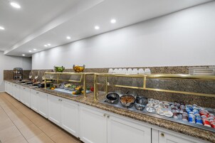 Uma mesa de buffet com diversos alimentos e bebidas.