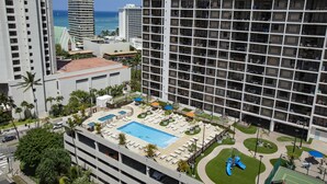 Hotel com piscina no terraço, área de recreação infantil e vista para o oceano.