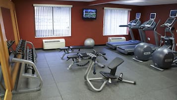 Academia com esteiras, bolas de exercício e aparelhos de musculação.