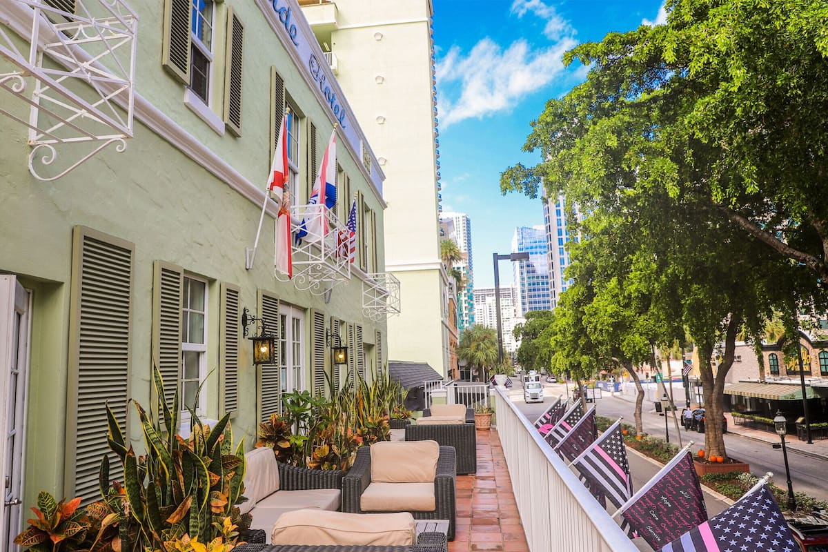 Hotel com área externa para sentar, bandeiras americanas e vista para a cidade.