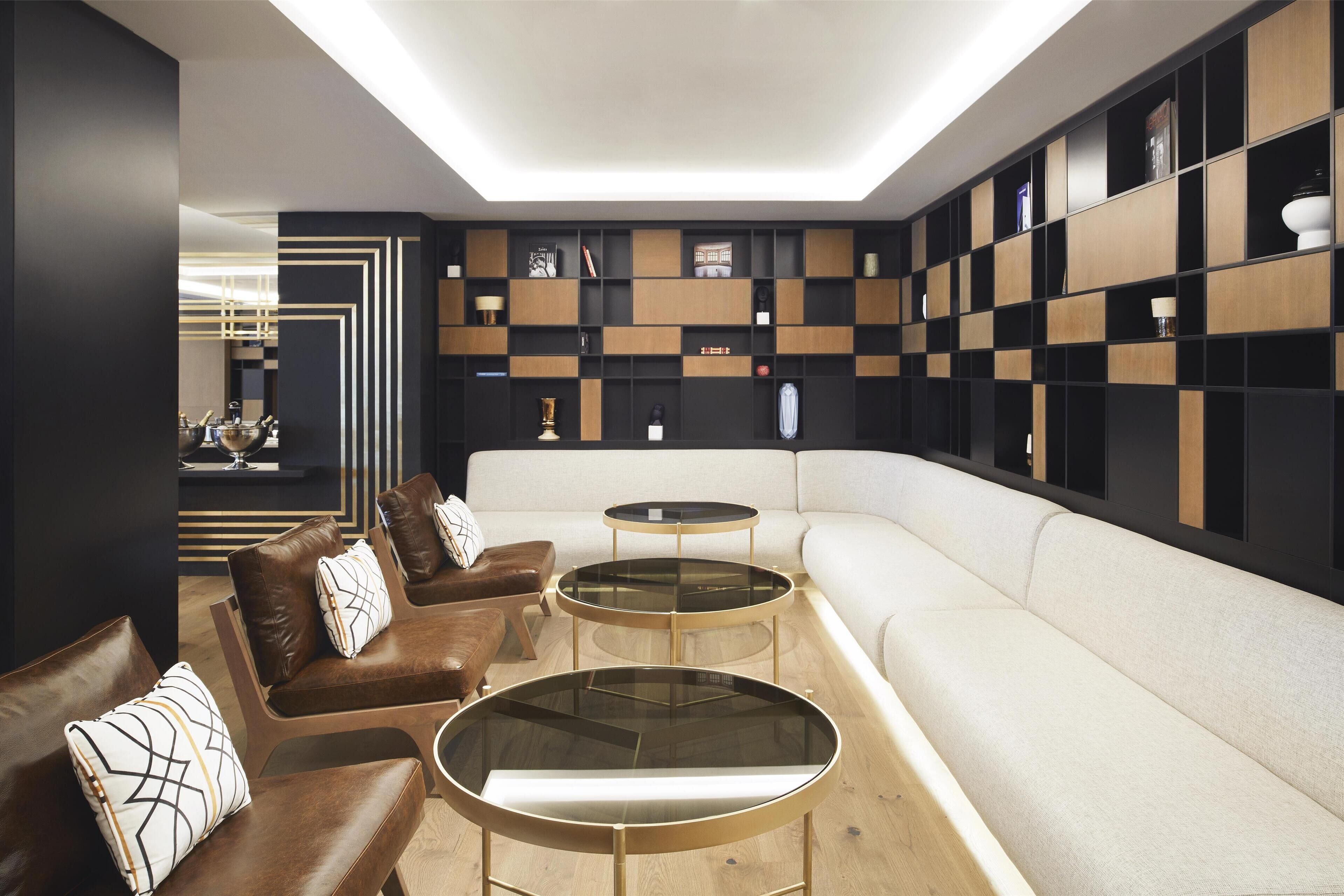 Uma área de lounge moderna com sofás de couro, mesas de centro de vidro e um design de parede quadriculado.