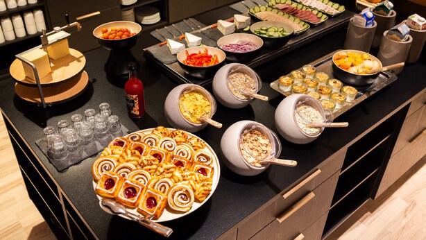 Buffet com diversos alimentos e um ralador de queijo.