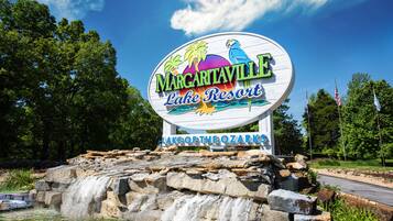 Placa do Resort Margaritaville Lake com uma cachoeira e palmeiras.