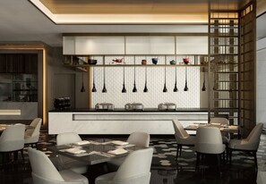 Um restaurante moderno com ilha central, área de estar e parede decorativa com luminárias pendentes.