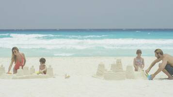 Na praia, praia de areia branca, espreguiçadeiras, guarda-sóis de praia