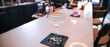 Um bar com uma taça de martini sobre um balcão de mármore.
