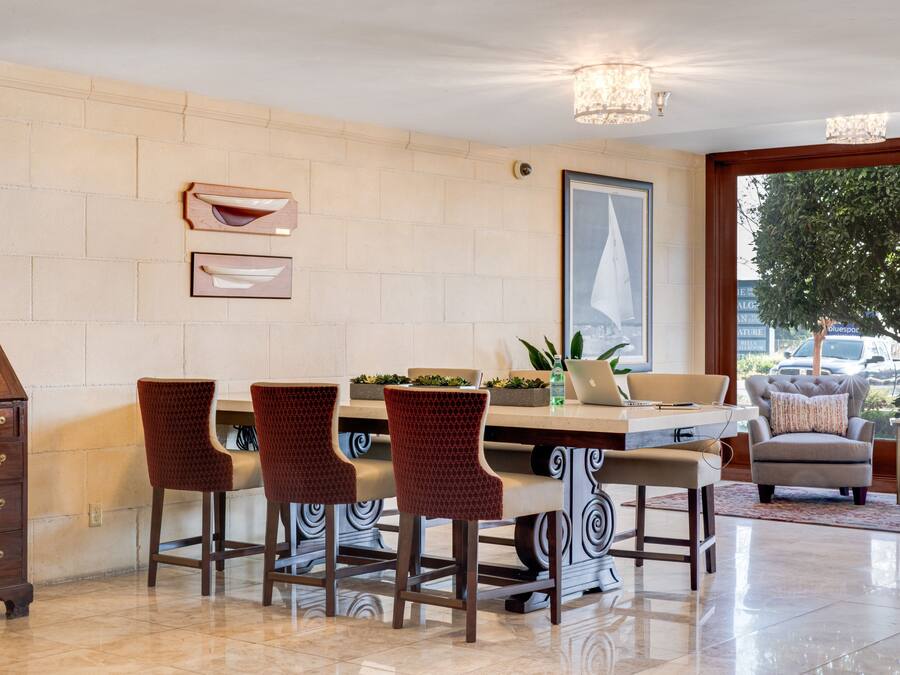Cozinha moderna com área de refeições, destacando uma ilha grande, banquetas e vista para o exterior.