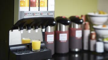 Máquina de café servindo suco de laranja, com diversas opções de café ao fundo.