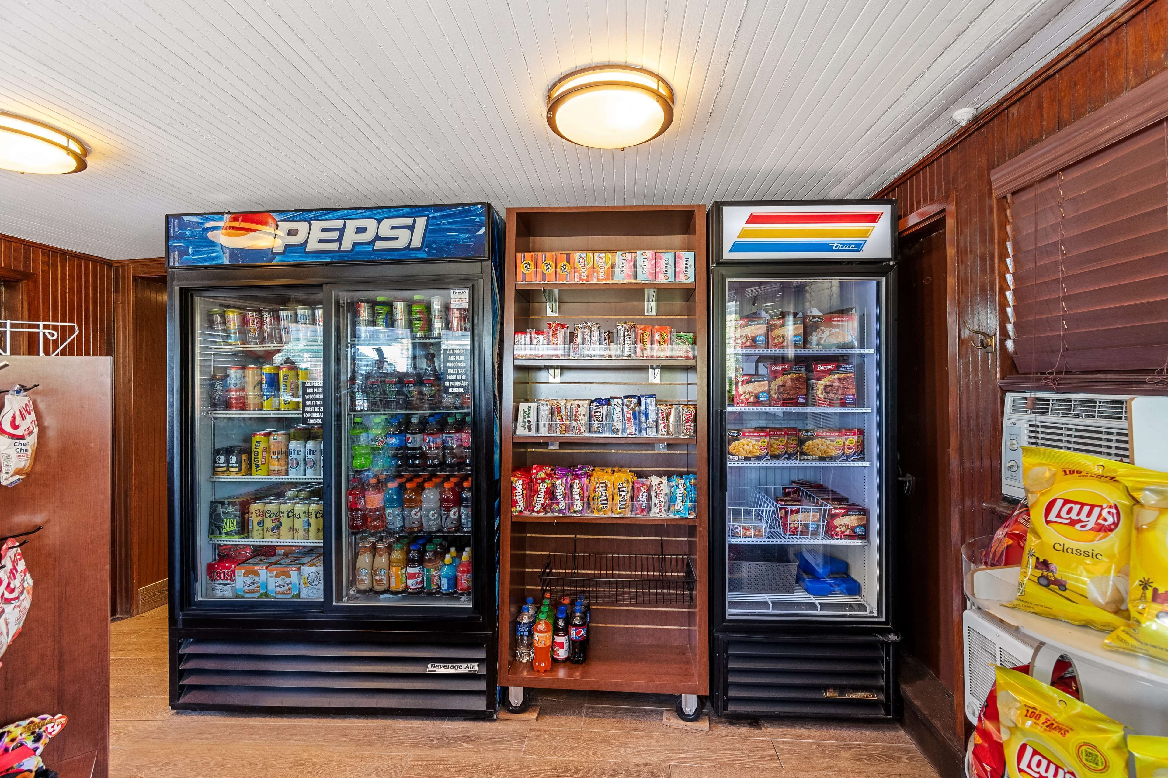 Uma área de máquinas automáticas com Pepsi, Tru e Lay's, e um freezer com diversos snacks.