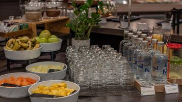 Buffet com diversos pratos e dispensadores de bebidas.