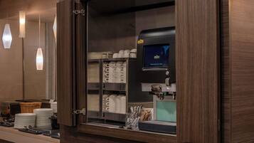 Uma cozinha moderna com cafeteira embutida e tela de exibição.