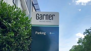 Placa de hotel para 'Garnier AN IHG HOTEL' com uma seta indicando a direção para estacionamento.