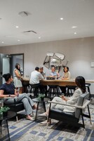 Uma sala de conferências com uma mesa comprida, várias cadeiras e um design moderno no teto.