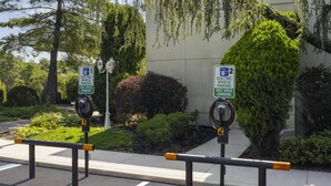Duas estações de carregamento para veículos elétricos, com placas a indicar que são apenas para veículos elétricos durante o carregamento.