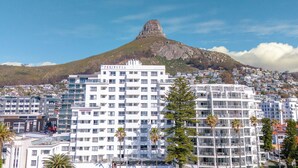 Um hotel com vários andares, varandas e vista para uma montanha.