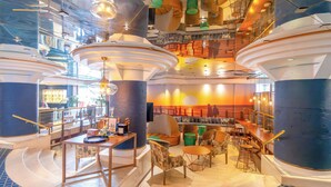 Interior moderno com área de bar, assentos e vista para o pôr do sol.