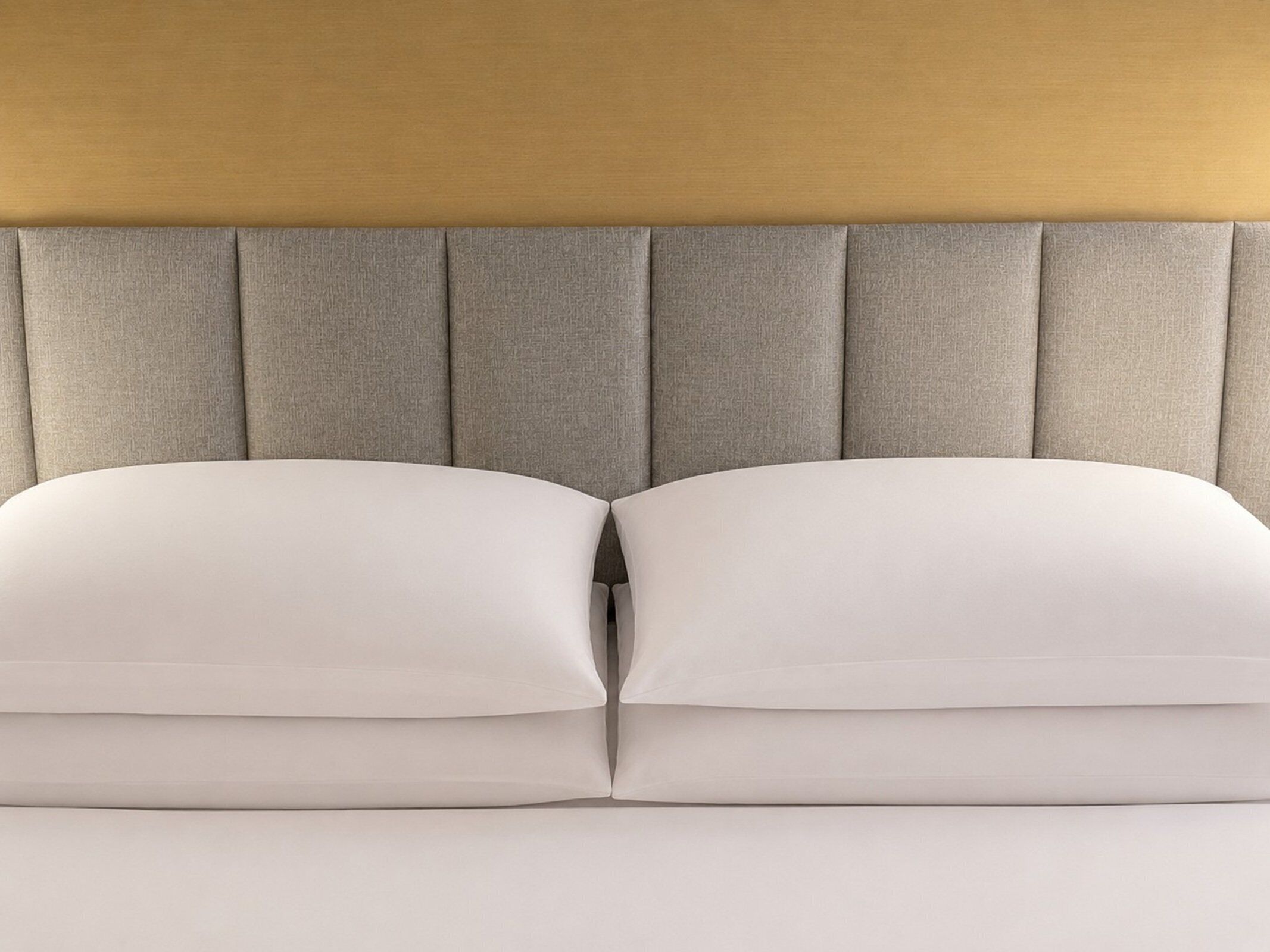 Uma cama com cabeceira e travesseiros.