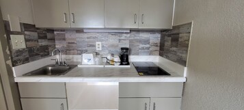 Um frigorífico, um micro-ondas, uma cafeteira/bule 