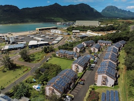 Um bairro residencial movido a energia solar, com várias casas, um grande edifício industrial e uma marina.