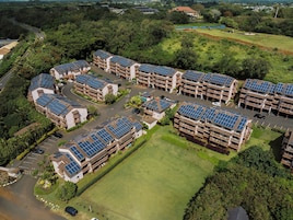 Um complexo residencial com vários edifícios, cada um com painéis solares nos telhados.
