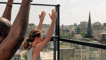 Um casal se exercitando em uma varanda com vista para a cidade.