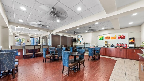 Um restaurante com cabines e mesas, um balcão com um menu e uma parede com imagens de comida.