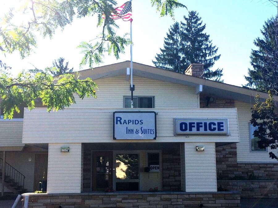Um edifício com uma placa que diz "RAPIDS INN & SUITES OFFICE".