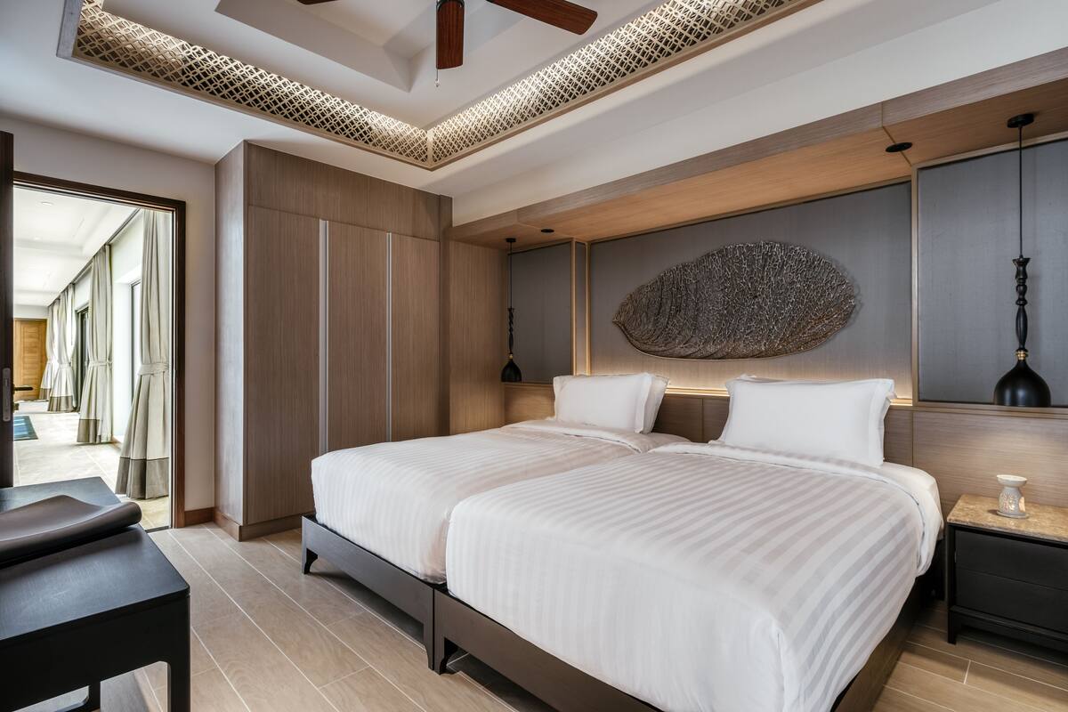 Quarto de hotel moderno com uma cama grande, uma escrivaninha e um guarda-roupa.