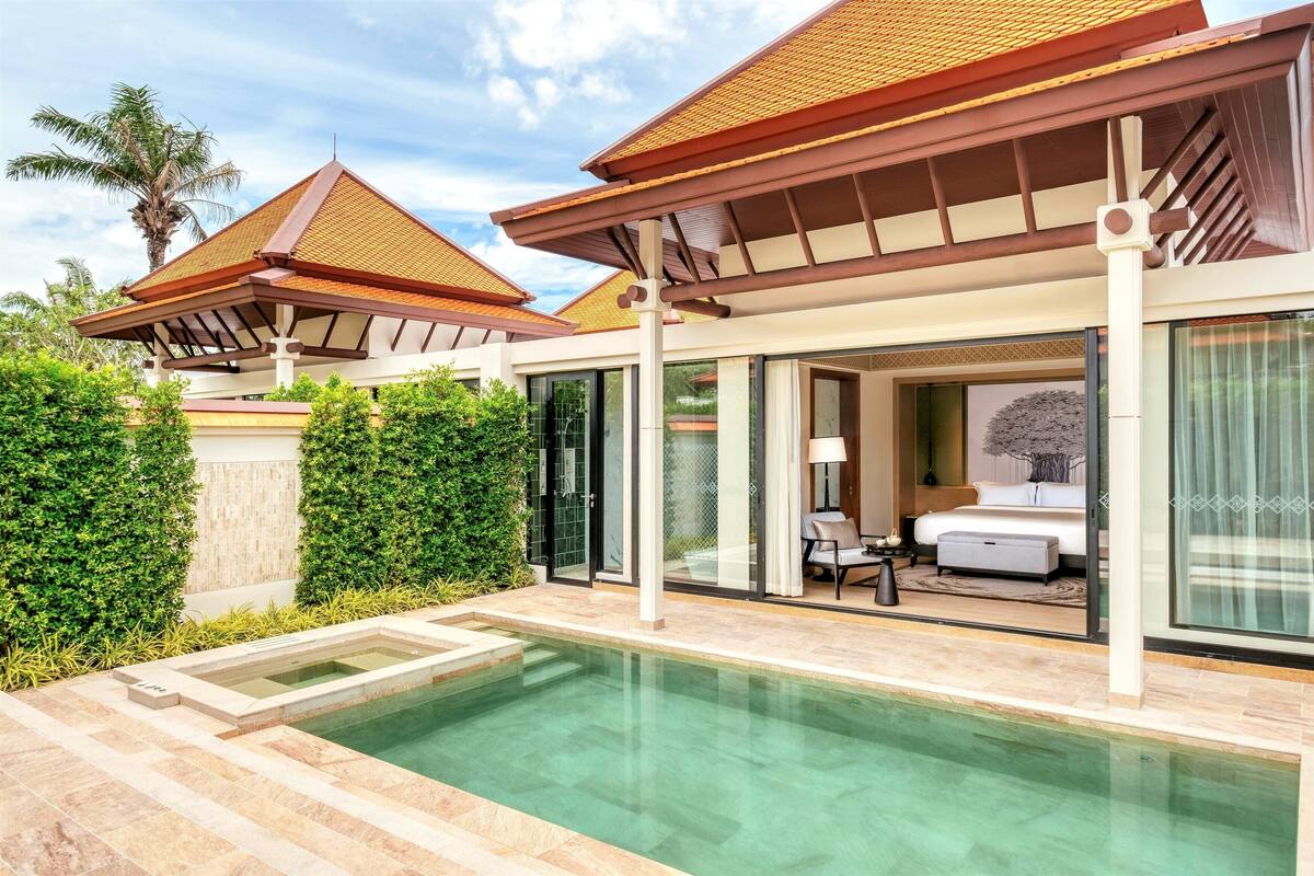 Uma villa moderna com piscina, portas de vidro que dão para um quarto e uma área externa coberta.