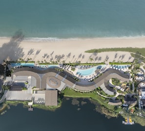 Vista aérea de um resort com piscina, praia e palmeiras.