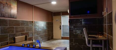Uma casa de banho moderna com uma banheira grande, um espaço de estar e uma secretária com uma cadeira.