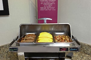 Buffet com bandejas identificadas de comida, incluindo peru, ovos e batatas.