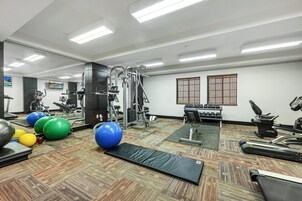 Uma academia com esteiras, bolas de exercício e aparelhos de musculação.