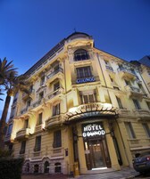 Um hotel histórico com varandas elaboradas e uma fachada clássica.