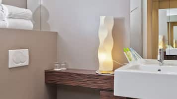 Uma casa de banho moderna com sanita, bidé, lavatório e toucador.