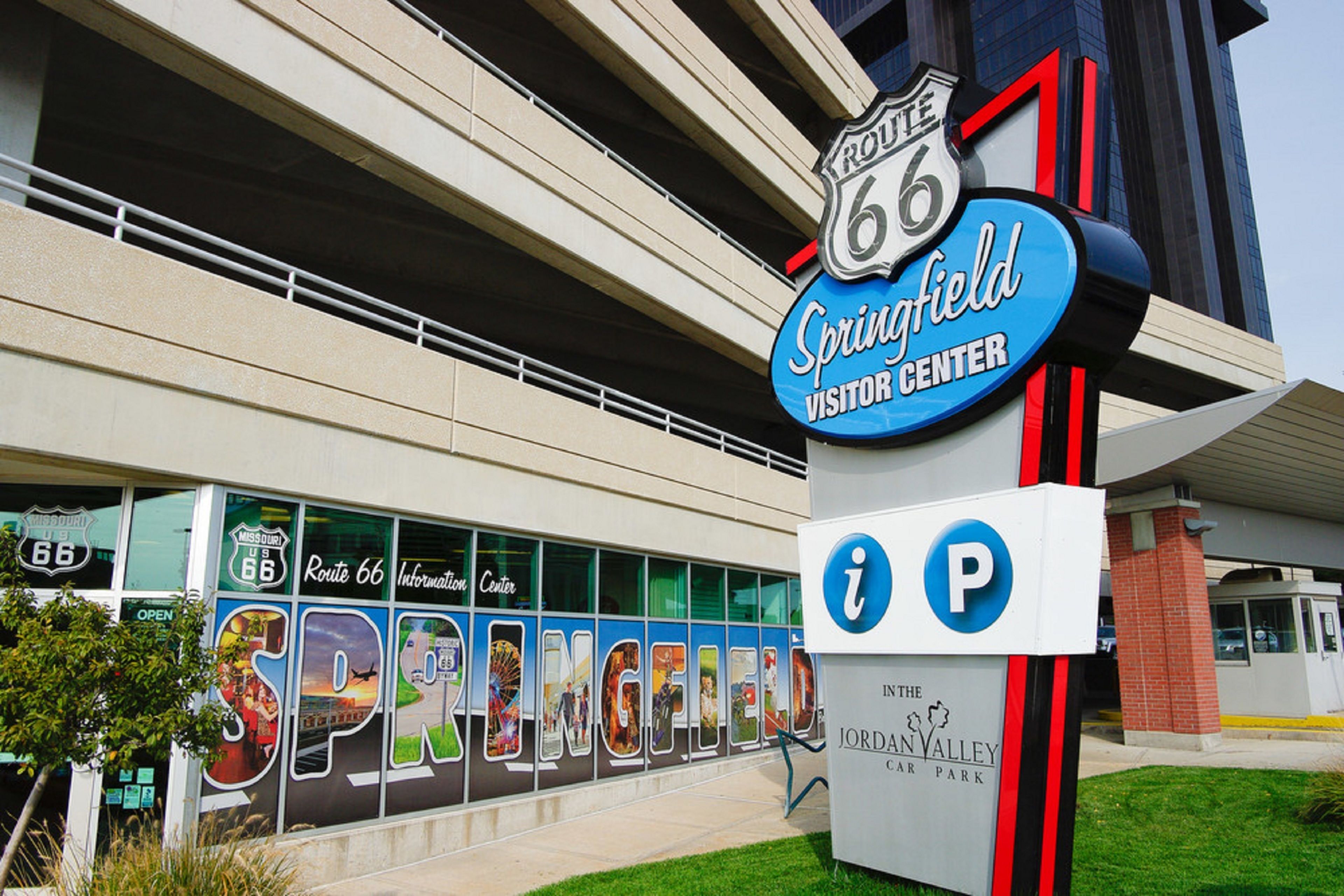 Um edifício com uma grande placa para o Springfield Visitor Center, Rota 66 e o estacionamento Jordan Valley.