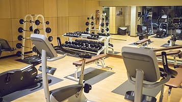 Uma academia com diversos equipamentos de exercício, incluindo esteiras, aparelhos de musculação e halteres.