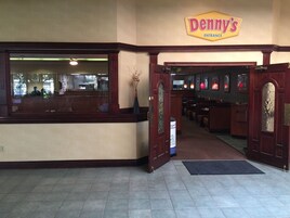 A entrada de um restaurante com a placa indicando 'Denny's'.
