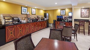 Restaurante de hotel com balcão, área de estar e diversos pontos de comida e bebida.