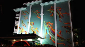 Um edifício com varanda e um mural de chamas coloridas.