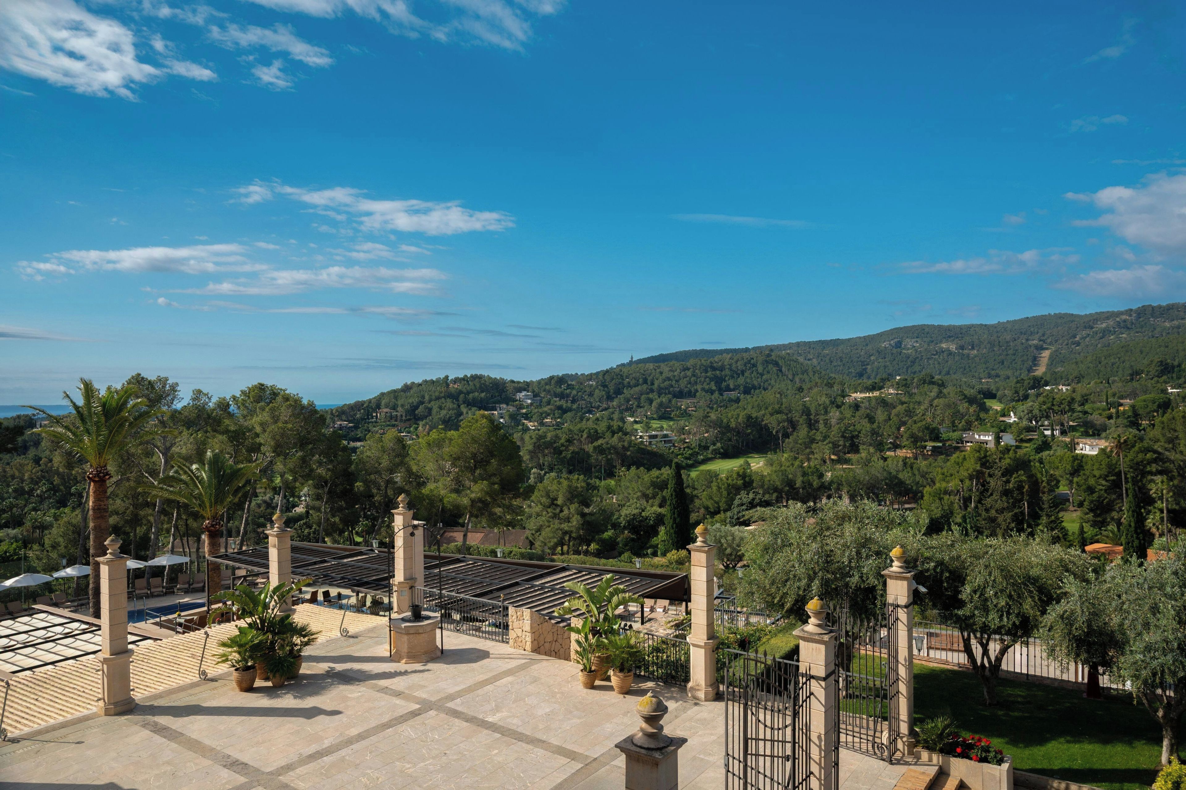 Terraço com vista para uma paisagem montanhosa, área de estar ao ar livre e piscina.