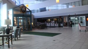 Um hall amplo com balcão de recepção, área de estar e entrada de vidro.