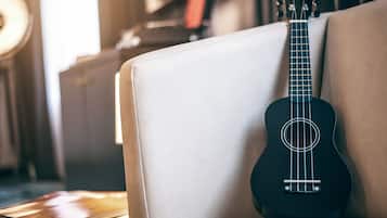Um ukulele sobre um sofá bege, com um livro ao lado.