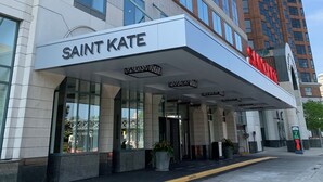 Um hotel chamado Saint Kate com fachada moderna, janelas amplas e entrada imponente.