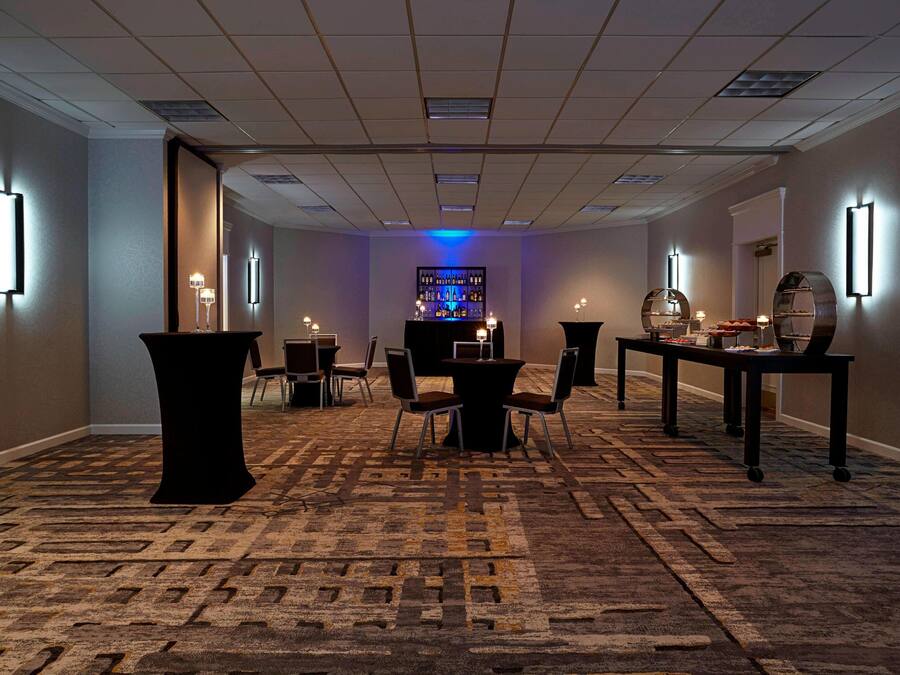 Um hall de hotel com balcão de recepção, área de estar e bar.