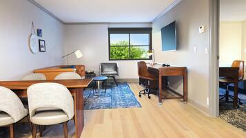 Uma sala de reuniões moderna com uma mesa de madeira, quatro cadeiras, uma escrivaninha e um janelão.