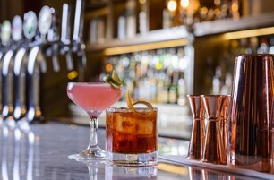 Um bar com um copo de martini e um copo de cocktail decorado com uma rodela de limão.